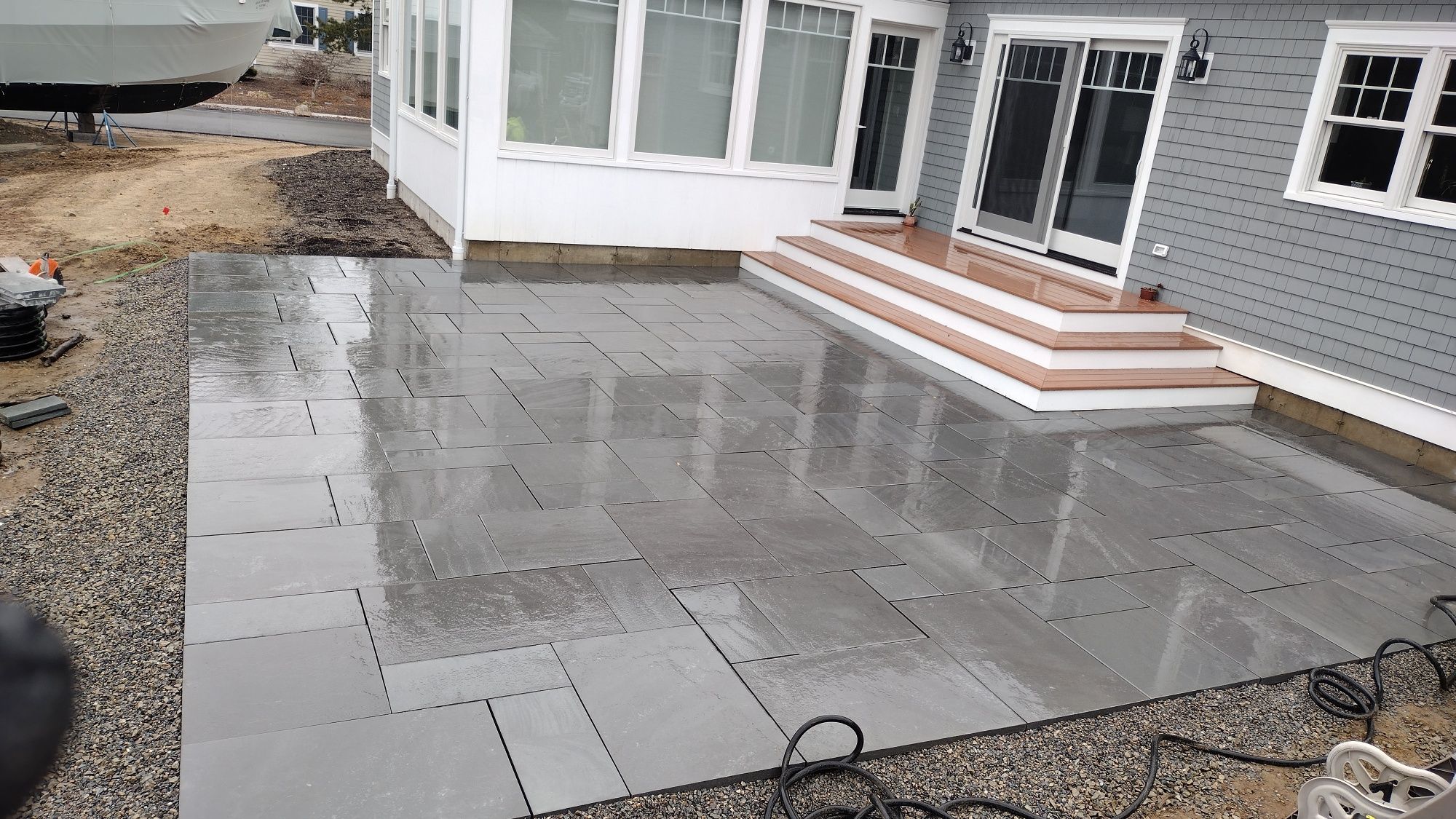 Bluestone Patio Installation with Wooden Steps | J & J lawncare and landscapes inc.